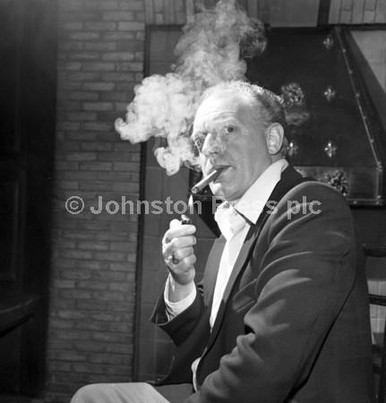 22577275-British actor Frank Windsor smoking a cigar backstage at the ...