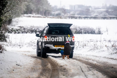 40084464-A child sat on a sledge is pulled by a vehicle along snow ...