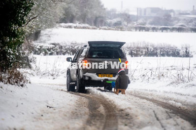 40084465-A child sat on a sledge is pulled by a vehicle along snow ...