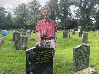 39084180-John Bettles, tends to the grave of his daughter, Michelle ...