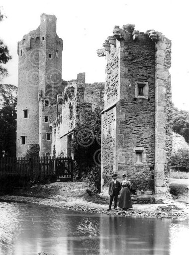 39598762-A gentleman and lady are stood by the moat and the ruins of ...