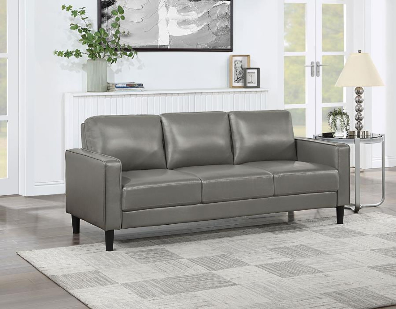 The Ruth Upholstered Track Arm Faux Leather Sofa Grey sold at Hilton Furniture serving Houston TX and surrounding areas