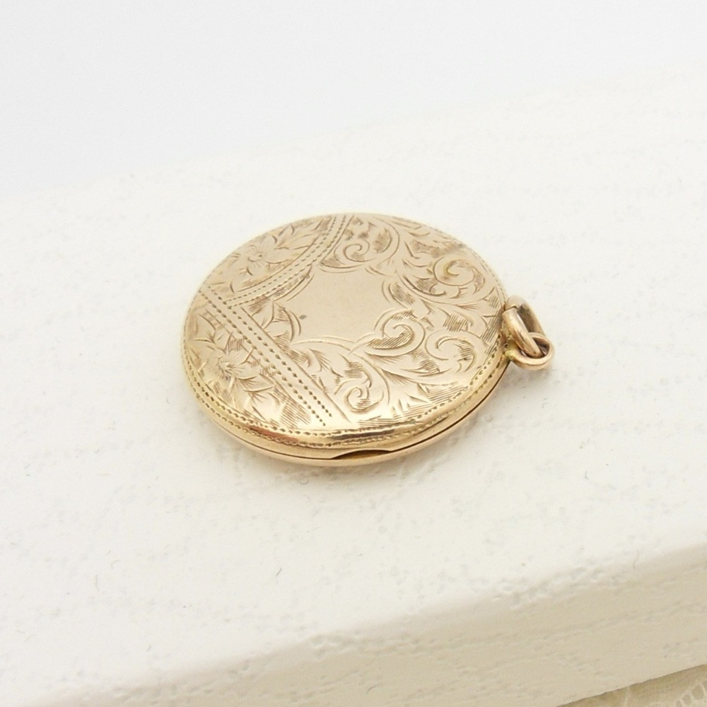 Antique circular 9ct gold locket with ornate engravings