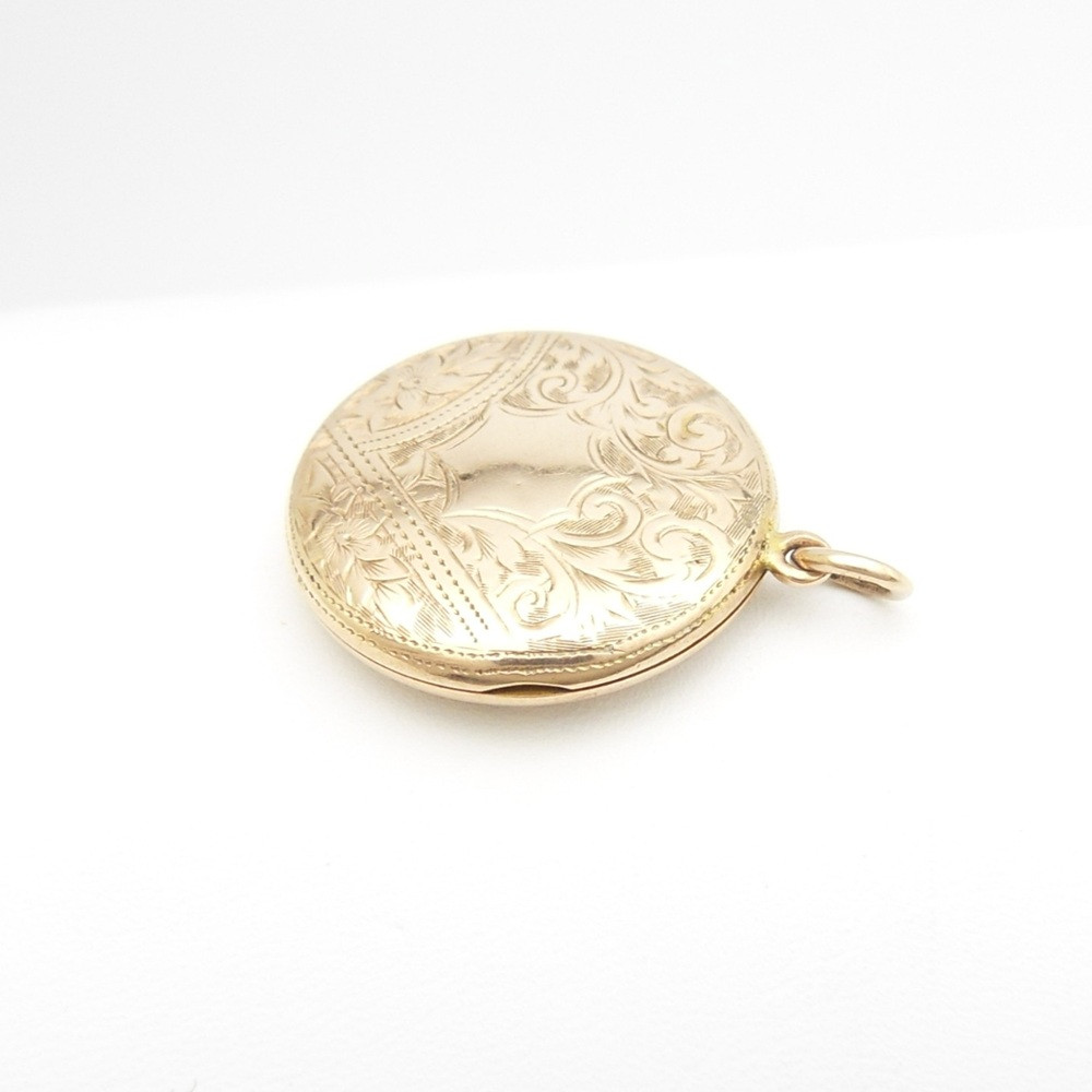 Antique circular 9ct gold locket with ornate engravings