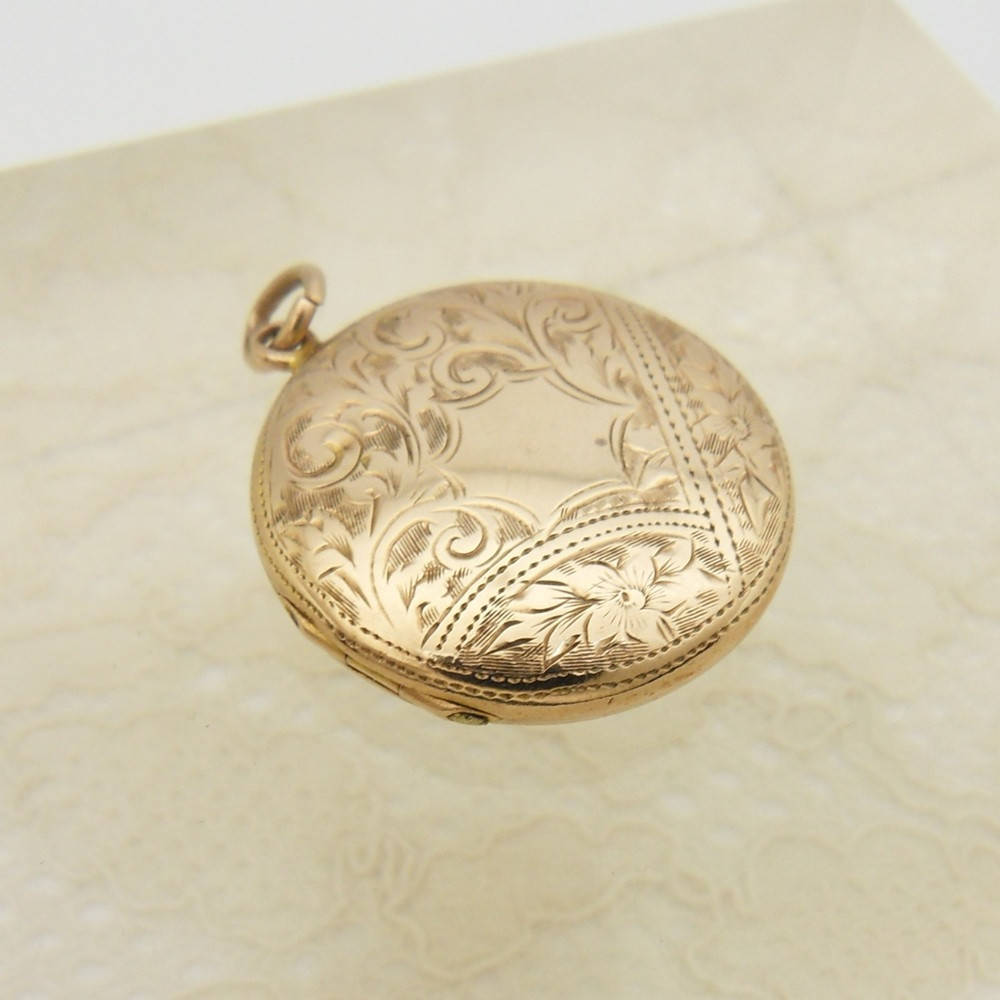 Antique circular 9ct gold locket with ornate engravings