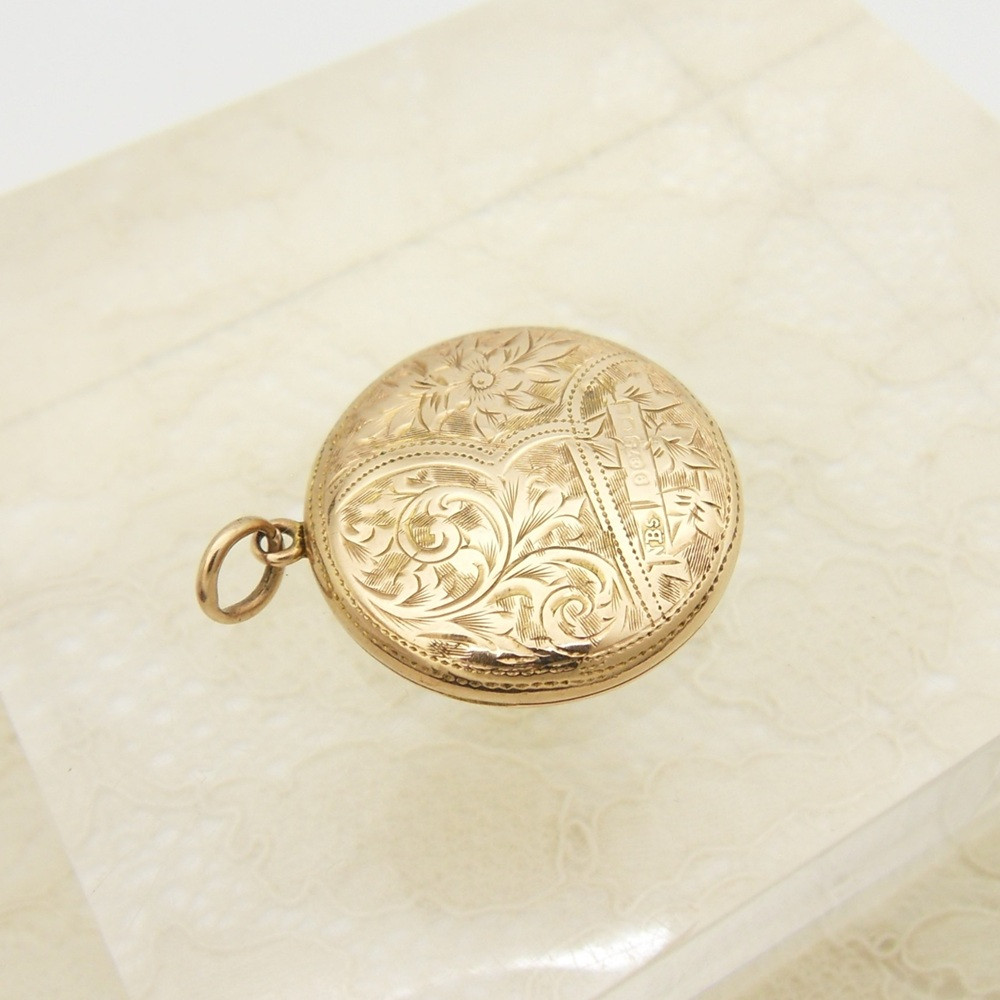 Antique circular 9ct gold locket with ornate engravings