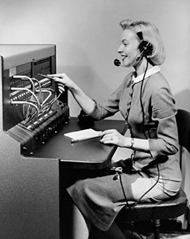 Side profile of female telephone operator operating telephone ...