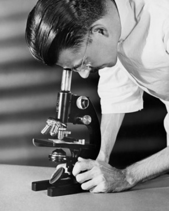Person Looking Through Microscope