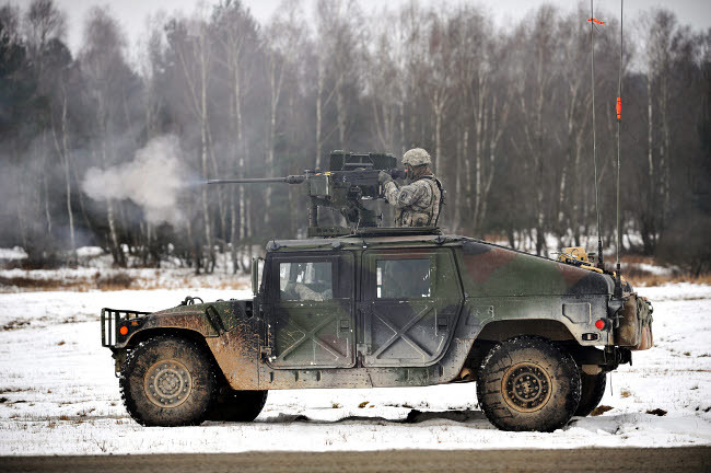 US Army paratrooper fires an M2 50-caliber machine gun atop a humvee ...
