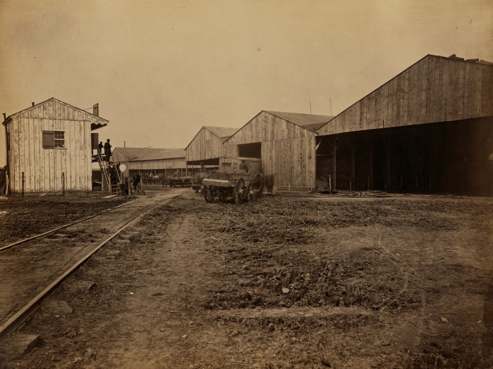 railroad tracks leading into a group of wooden barns. Poster Print ...