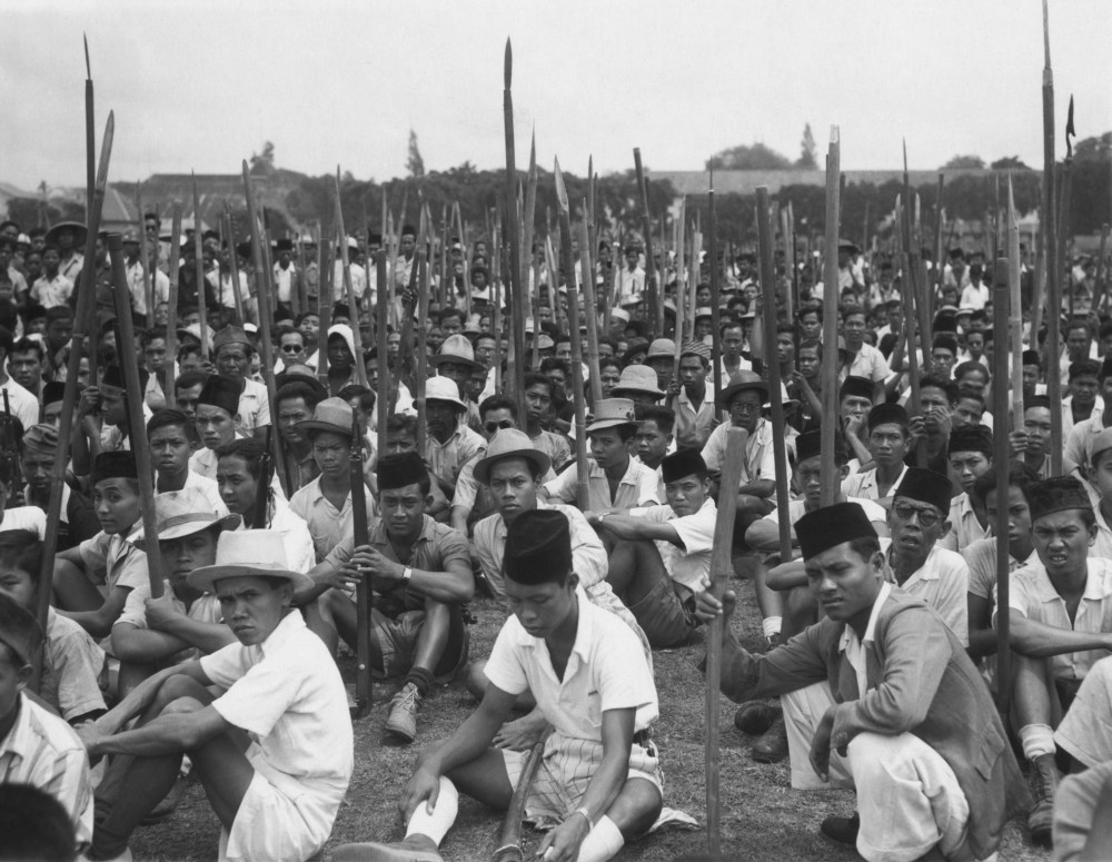 Young Indonesian Men Seated On Ground Holding Sharpened Bamboo Poles ...