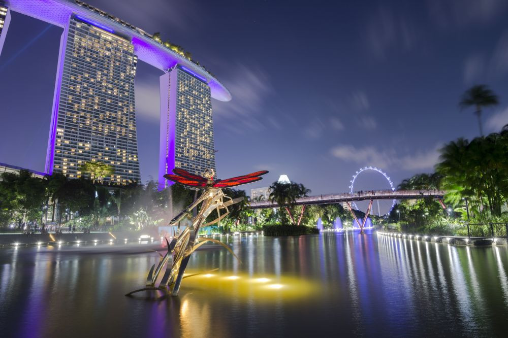 The Marina Bay Sands hotel and ferris wheel at night in Singapore ...
