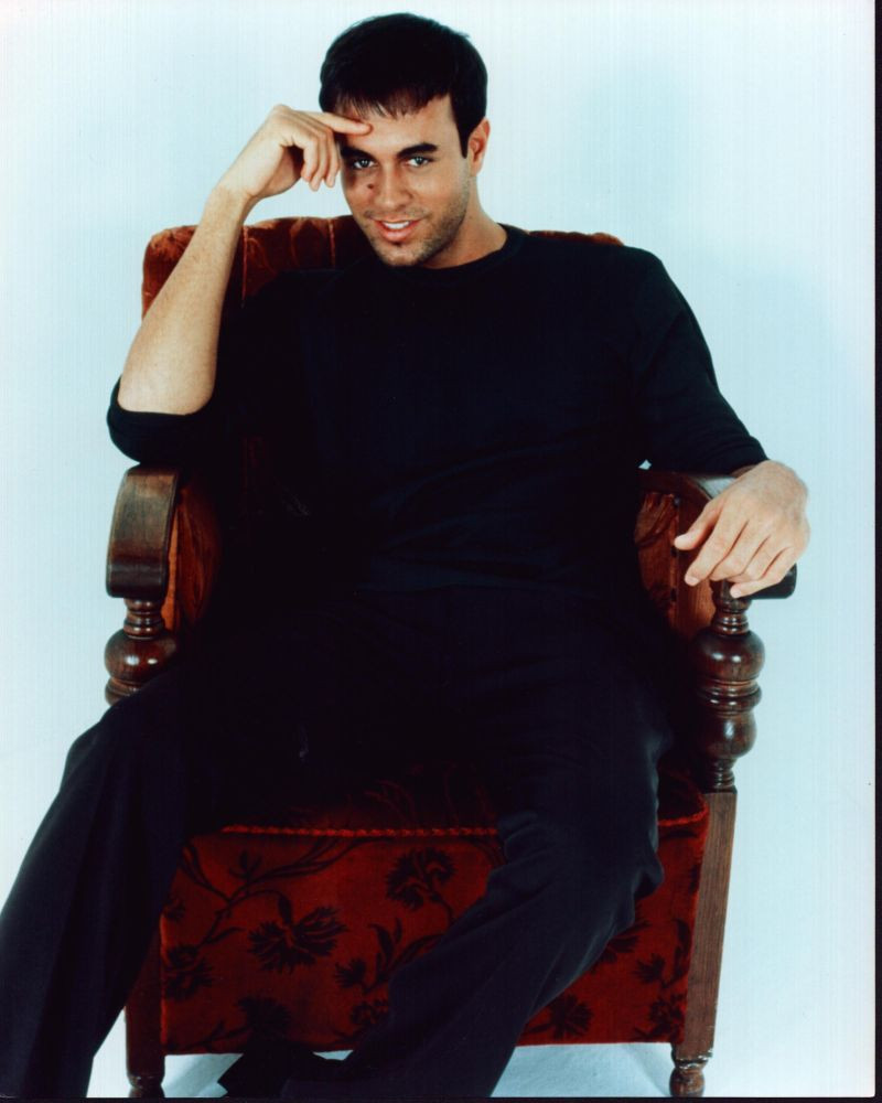 Enrique Iglesias In Red Chair Photo Print (8 x 10) - Posterazzi