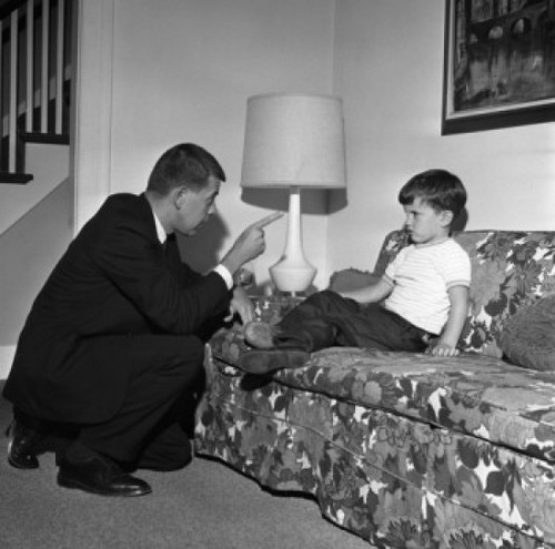 Father telling off son on living room sofa Poster Print - Item ...