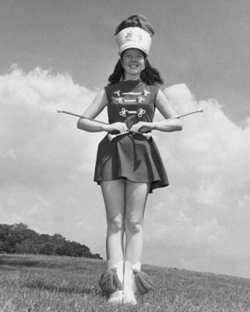 Drum majorette performing with two twirling batons and smiling Poster ...