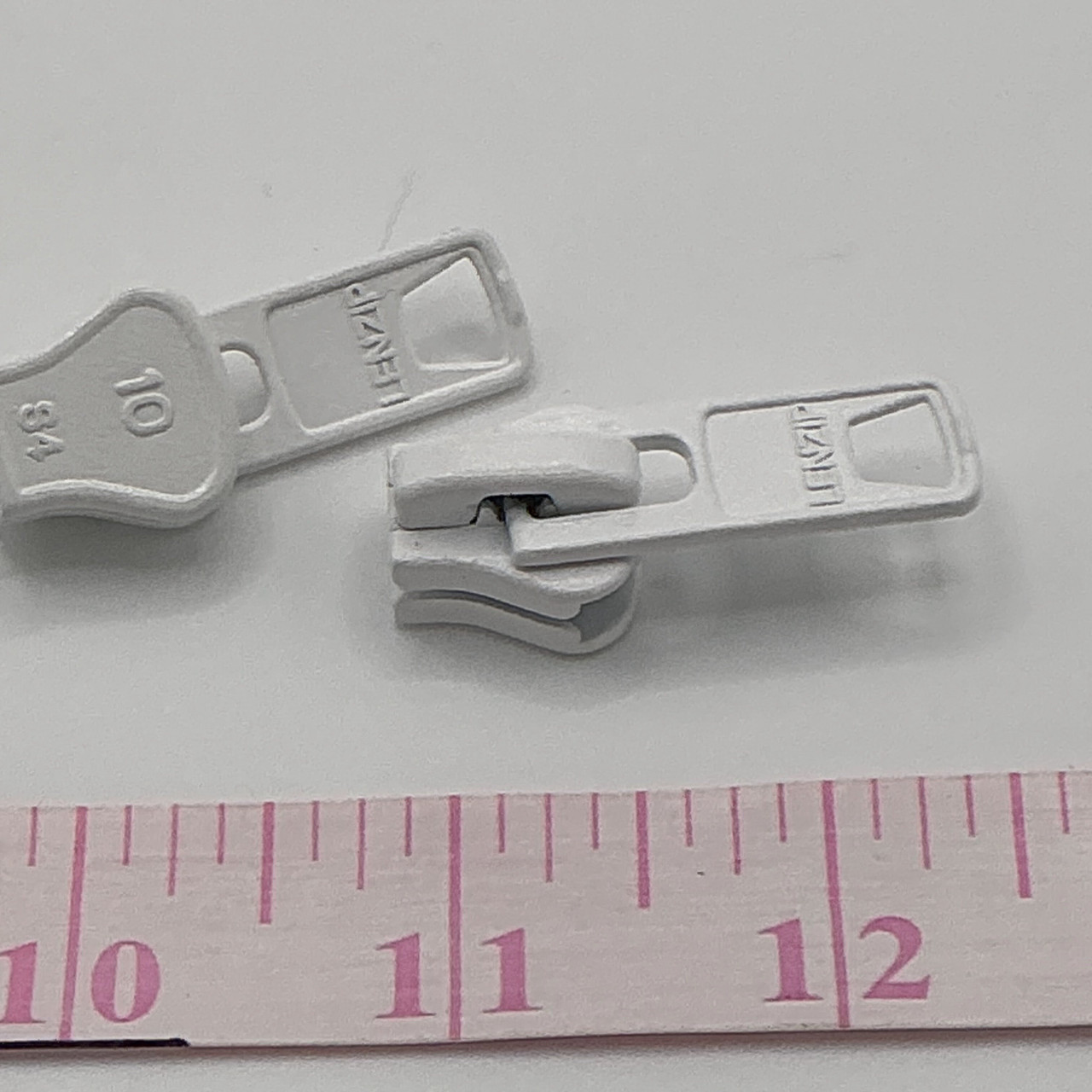 #10 MOLDED PULL. SINGLE PULL WHITE SELF LOCKING - Fabric Warehouse